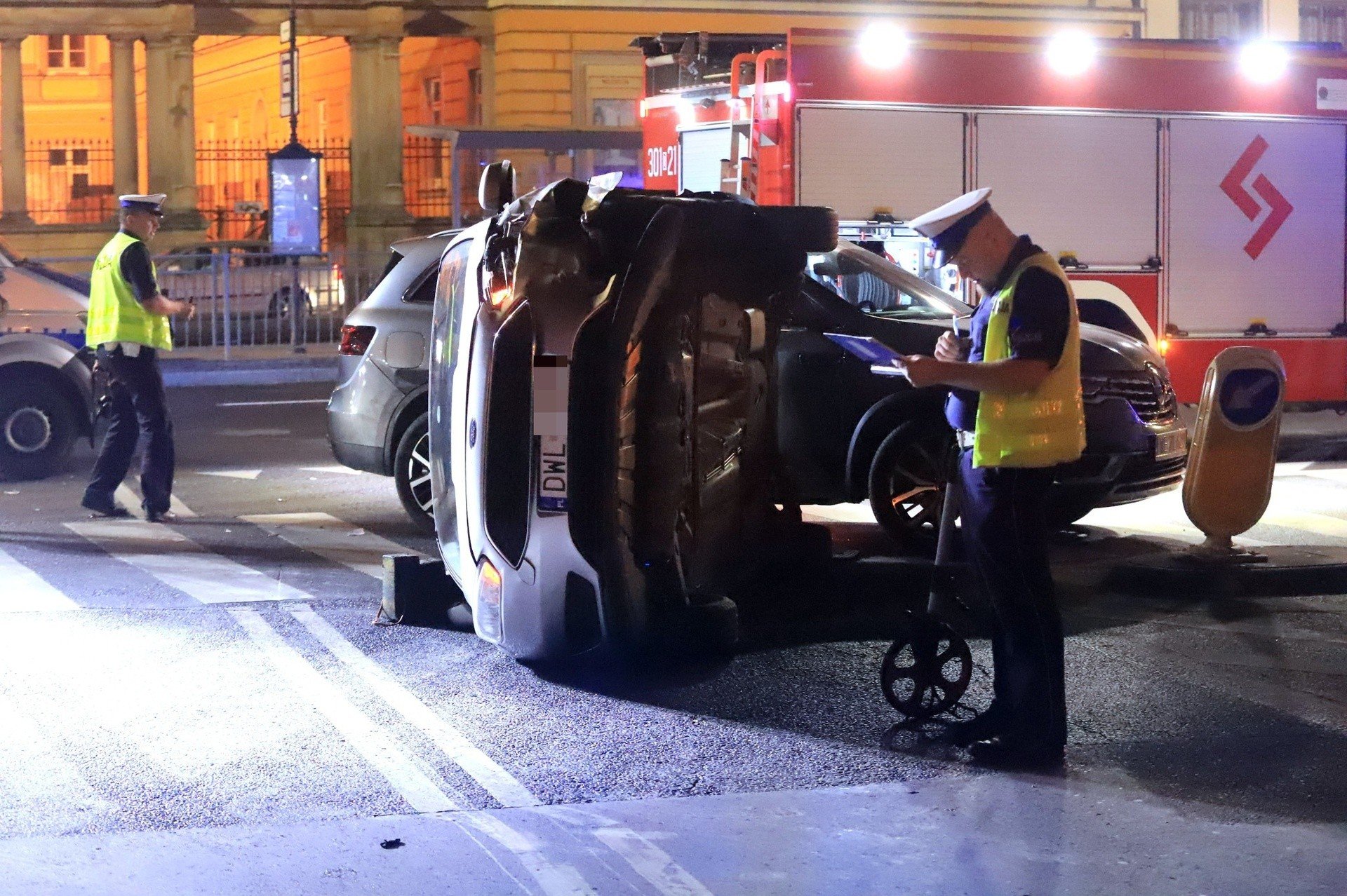 Wypadek dwóch aut w centrum Wrocławia. Samochód na boku, jedna osoba ...